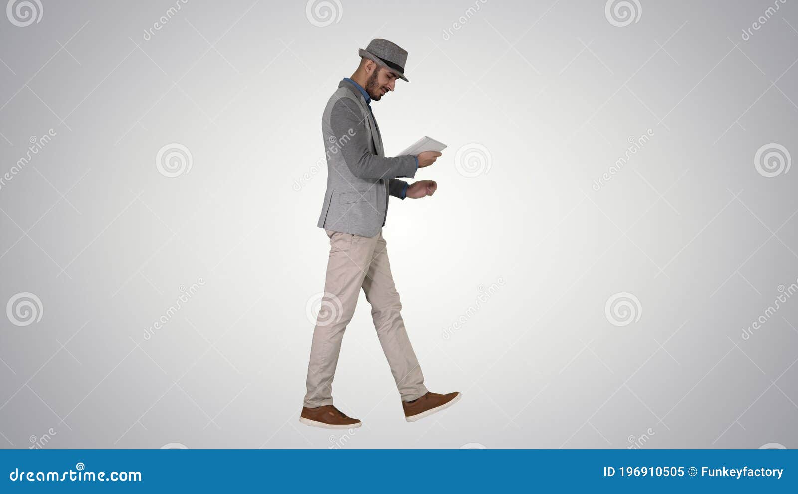 Casual Man Using Tablet and Smiling while Waking on Gradient Bac Stock ...