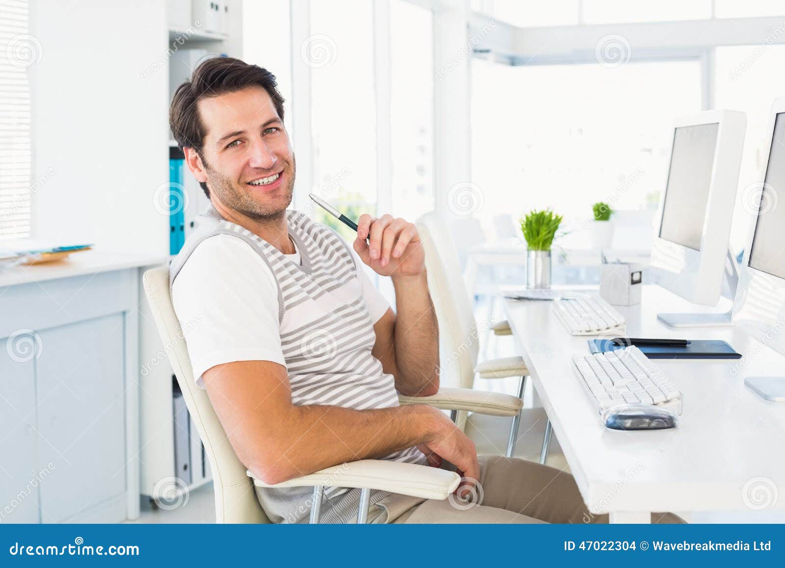 Casual Young Man with Computer in a Bright Office Stock Photo - Image ...