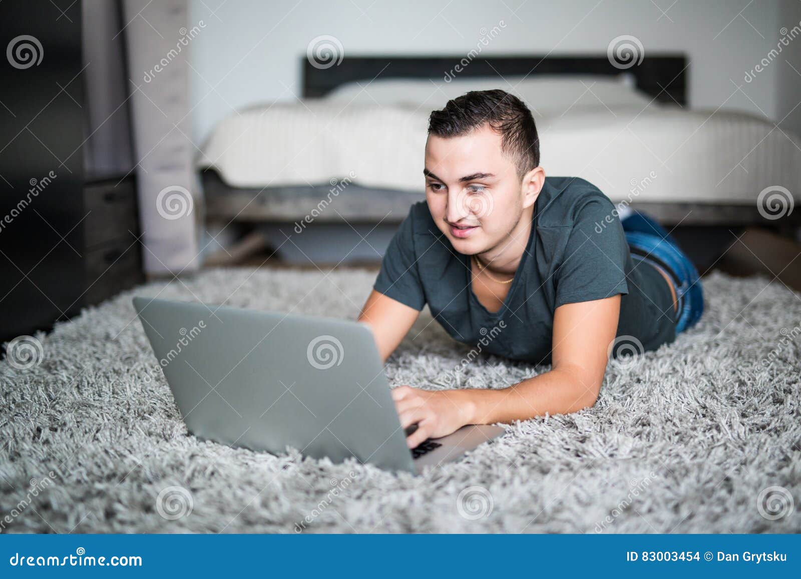 Casual Young Man Laying on Floor at Home, Browsing Internet Stock Photo ...
