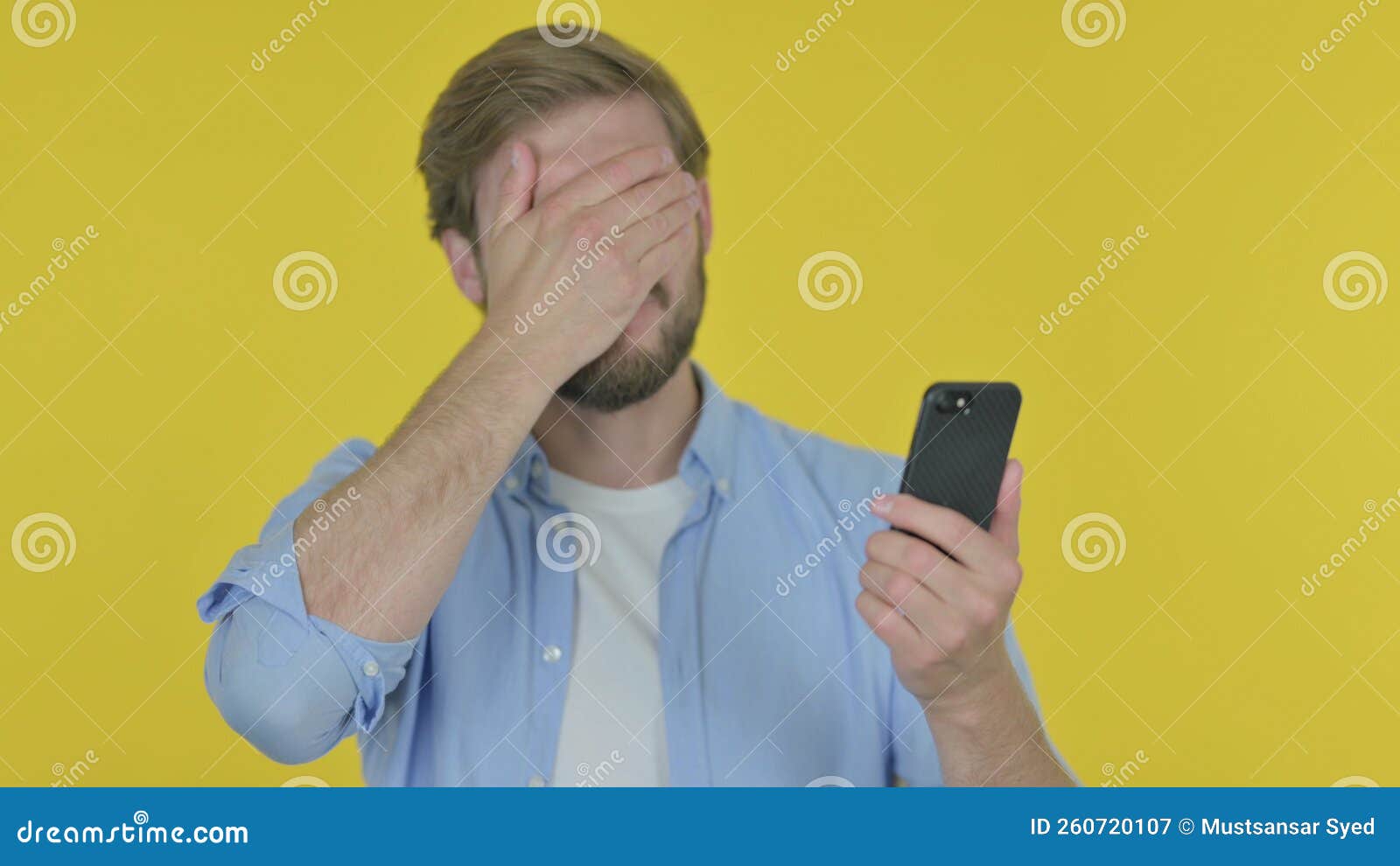 Young Man Loss on Smartphone on Yellow Background Stock Image - Image ...