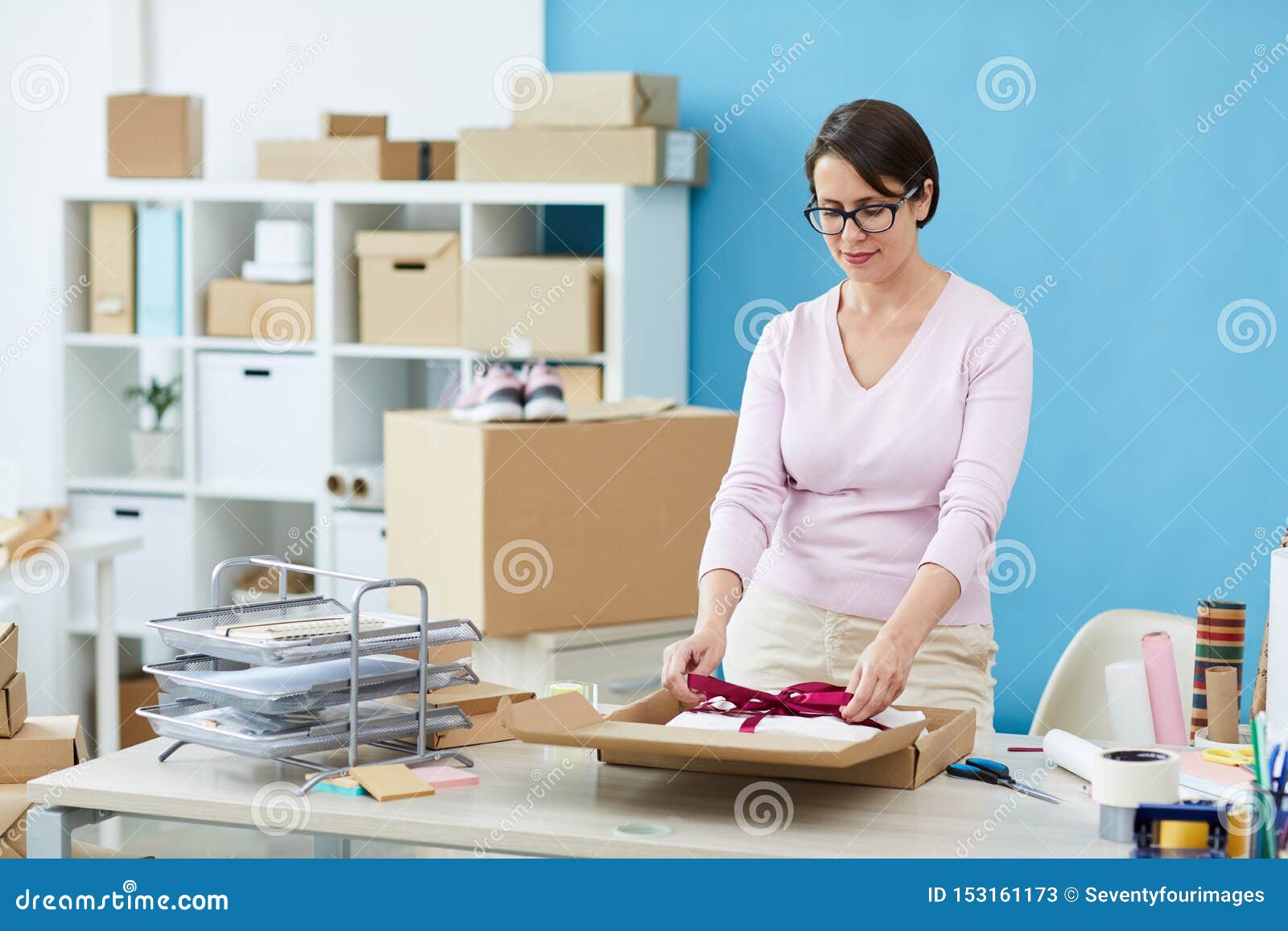 Casual Young Packing Manager Tying Knot on Top of Wrapped Order Stock ...