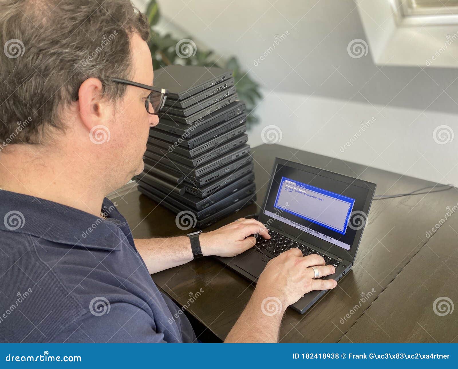 A Casually Dressed Caucasian Middle Aged Man is Installing a Laptop ...