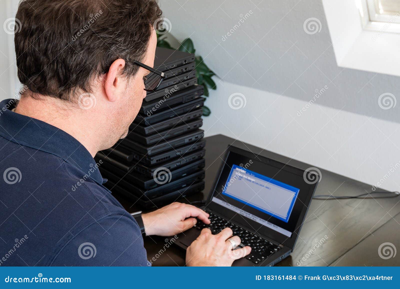 A Casually Dressed Caucasian Middle Aged Man is Installing a Laptop ...