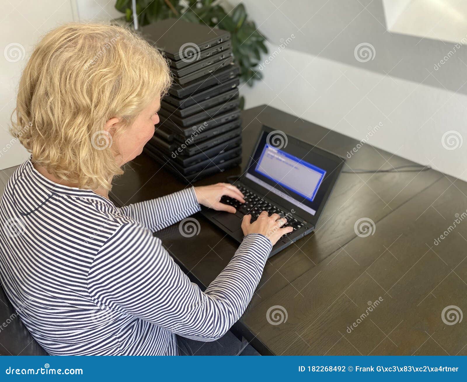 A Casually Dressed Caucasian Middle Aged Woman is Installing a Laptop ...