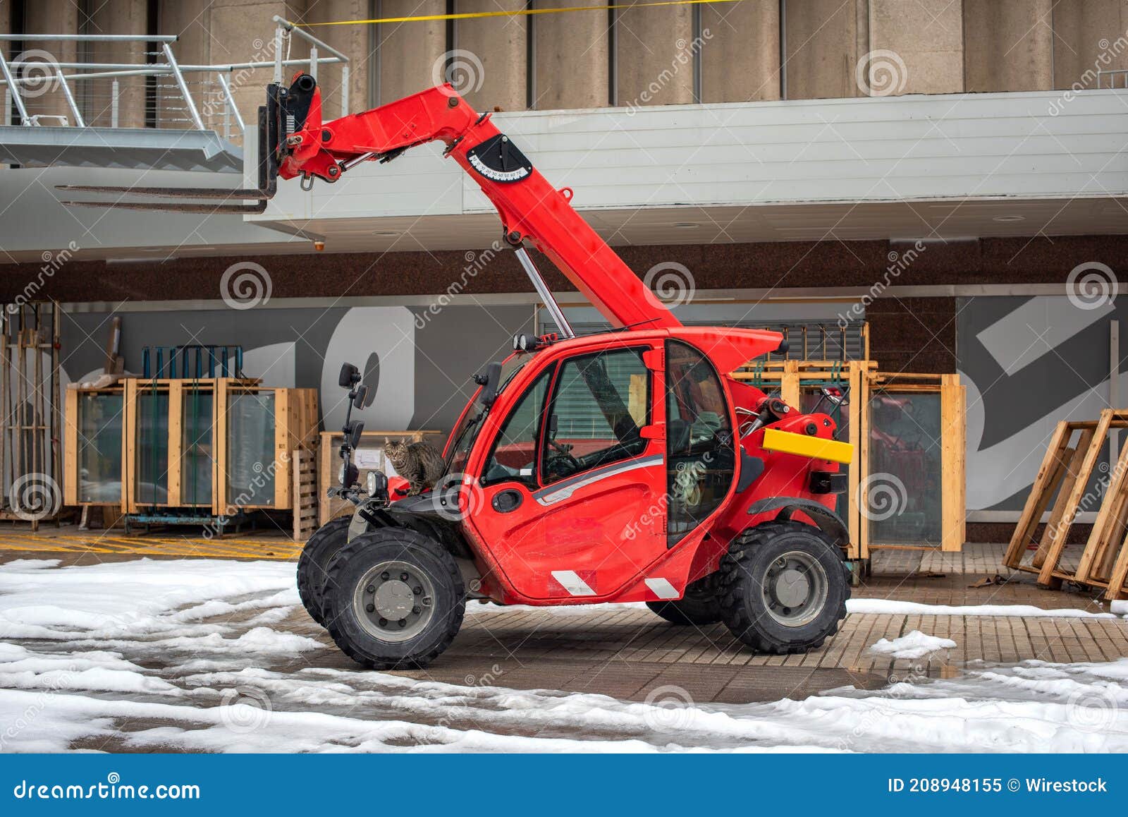 Cat Sitting on a Red Loader Parked in the Snow Stock Image - Image of ...