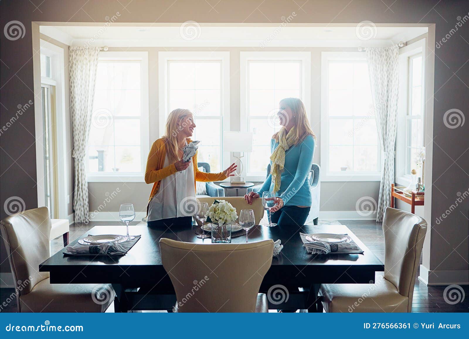 Catching Up while Setting Up the Dining Table. Two Women Setting Up the ...