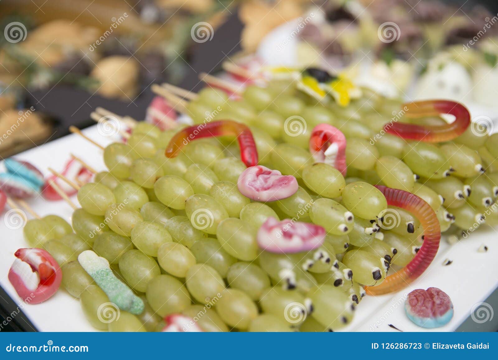 Caterpillars from the Rows of Grapes and Scattered on it Colored Sweets ...