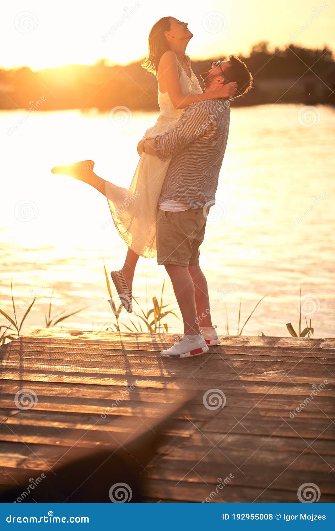 Beardy Guy Hugging, Lifting Up His Girlfriend at Sunset by the River ...