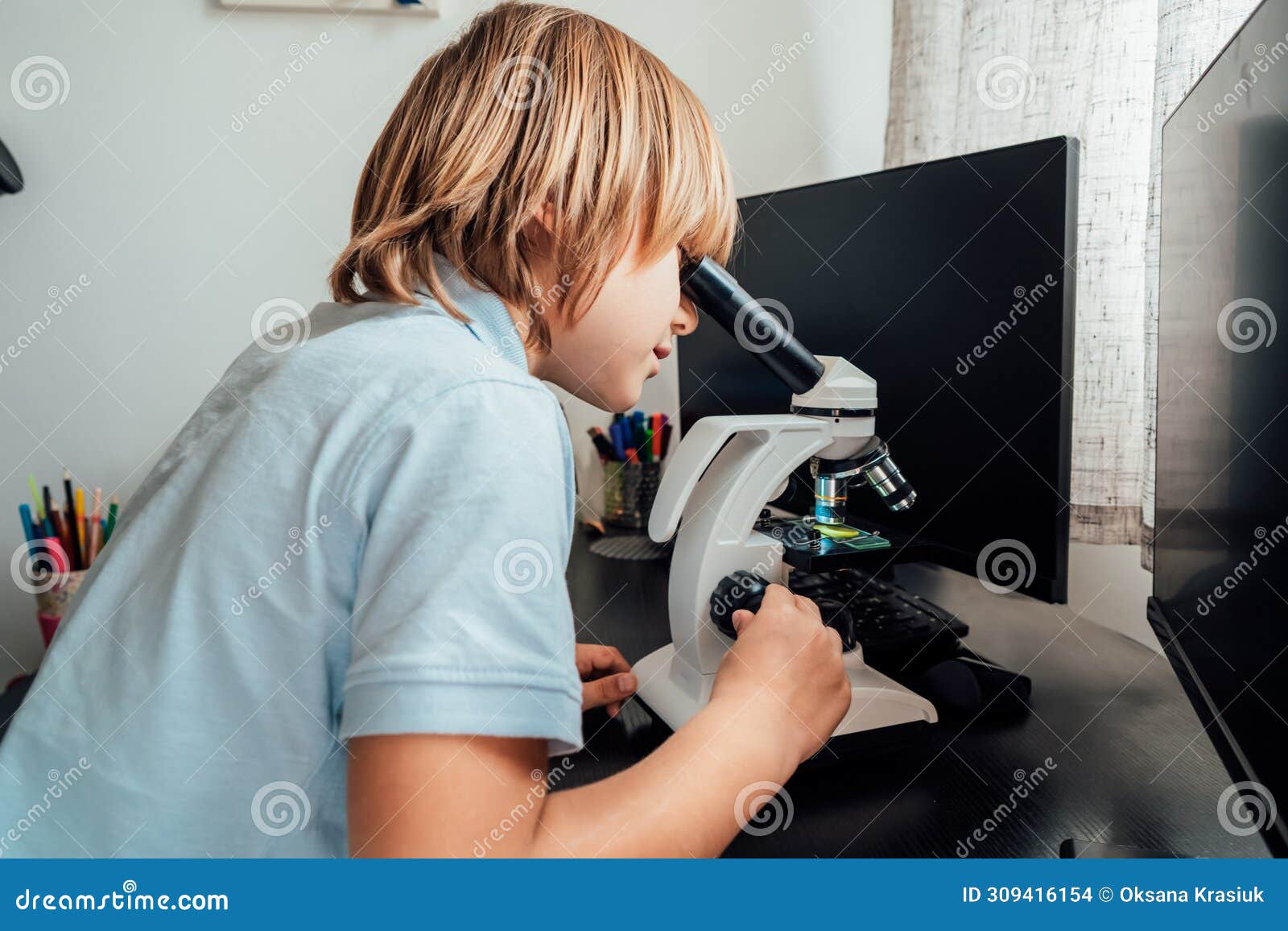 Caucasian Boy Using a Microscope at Home at His Study Place. Child ...