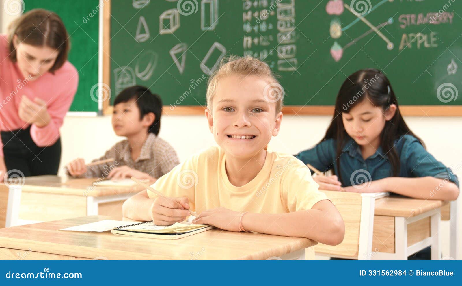 Caucasian Child Smiling at Camera while Doing Classwork at Classroom ...