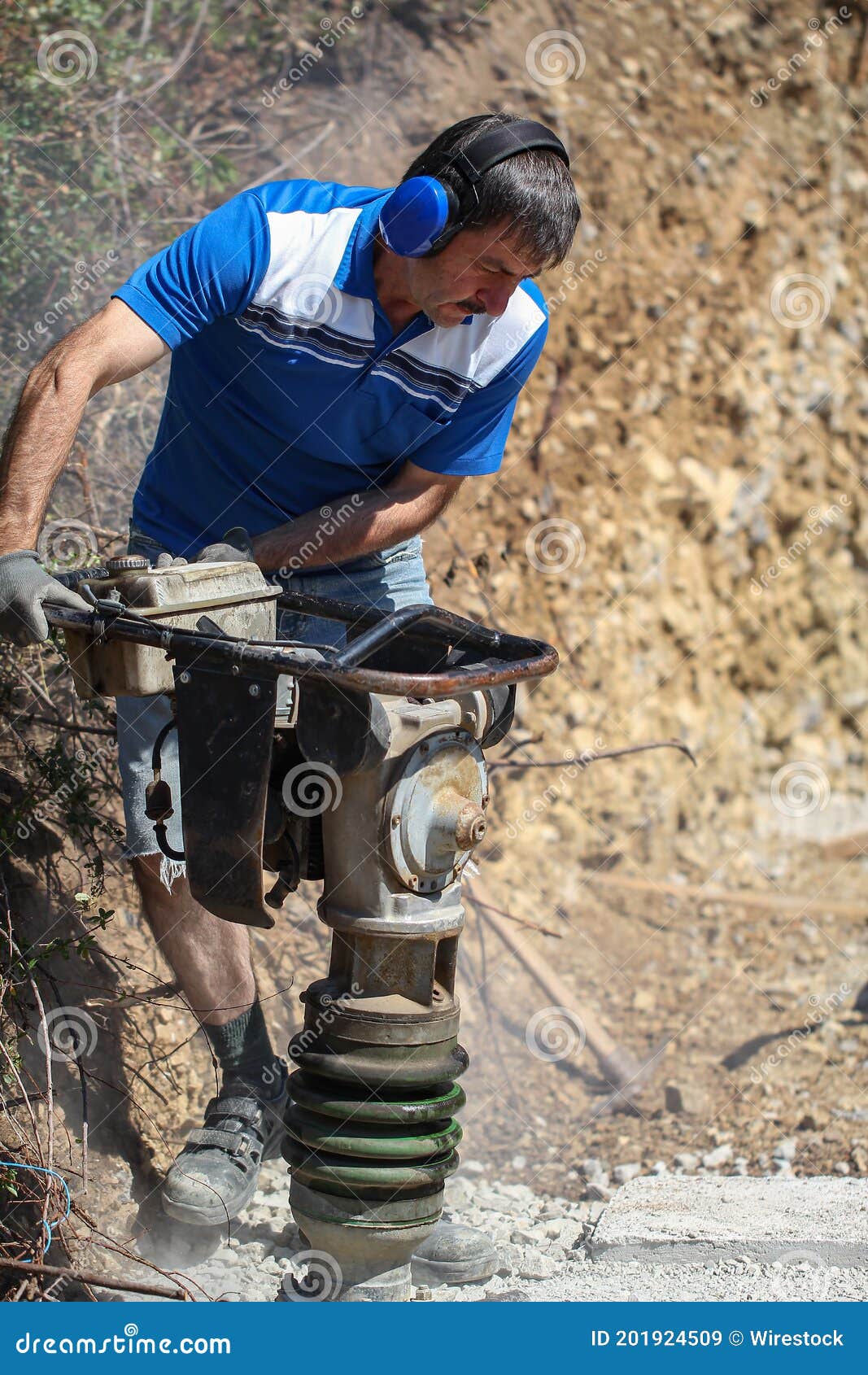 Caucasian Construction Worker Compacting Soil Using a Tamping Rammer ...