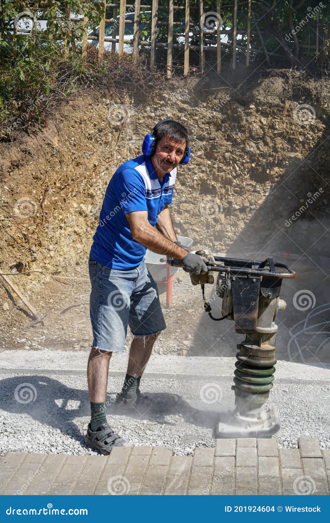 Caucasian Construction Worker Compacting Soil Using a Tamping Rammer ... Caucasian Construction Worker Compacting Soil Using a Tamping Rammer ...