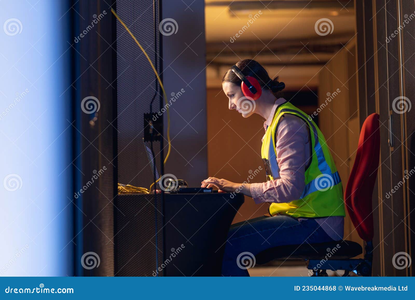 Caucasian Female Engineer Wearing Ear Plugs Using a Laptop in Computer ...