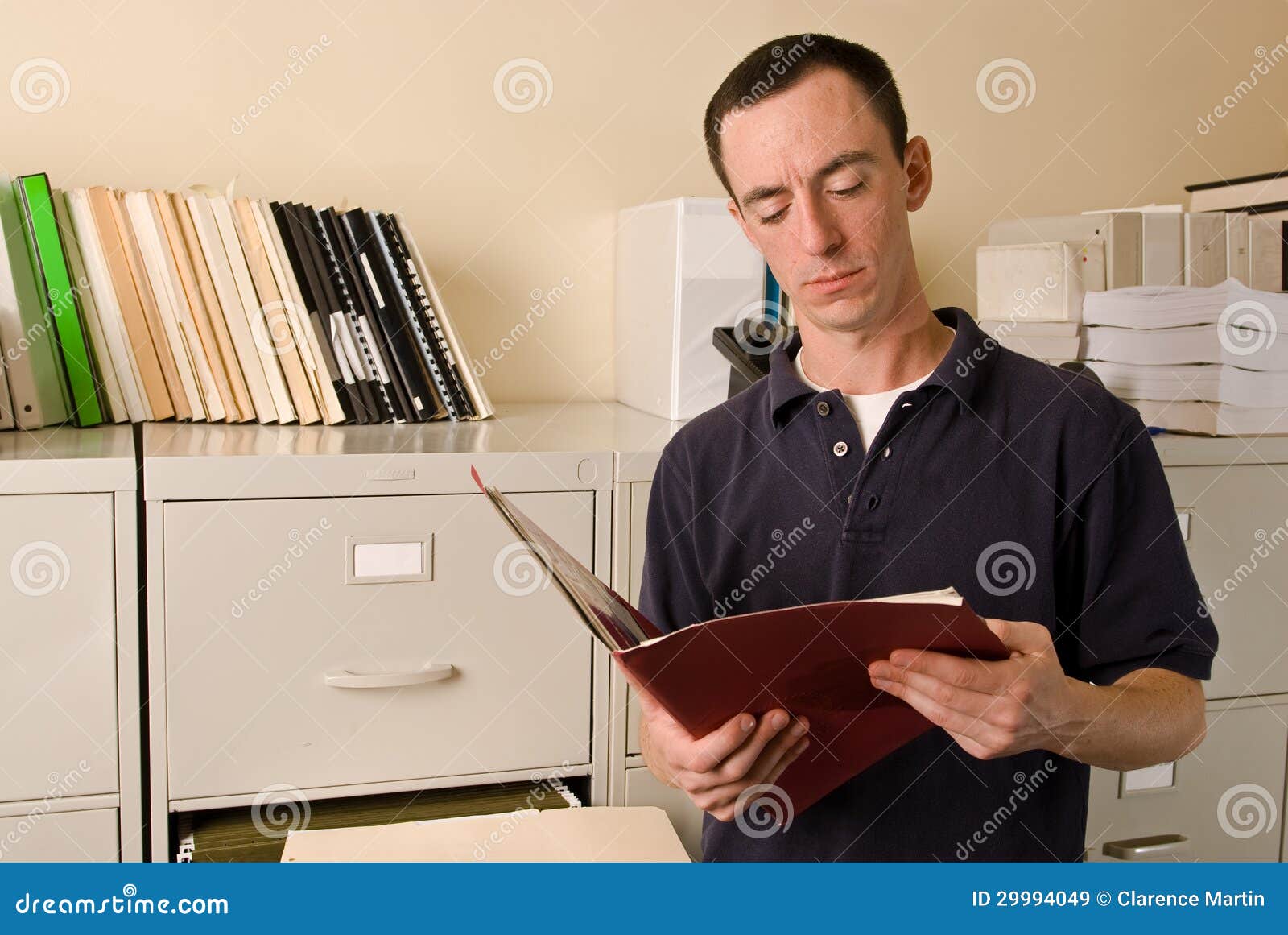 Caucasian Male in File Room Reading Papers Inside a Folder Stock Image ...