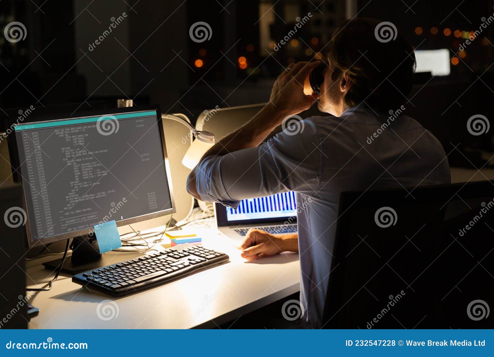 Caucasian Male Programmer Sitting at Desk, Drinking Coffee, Using ...