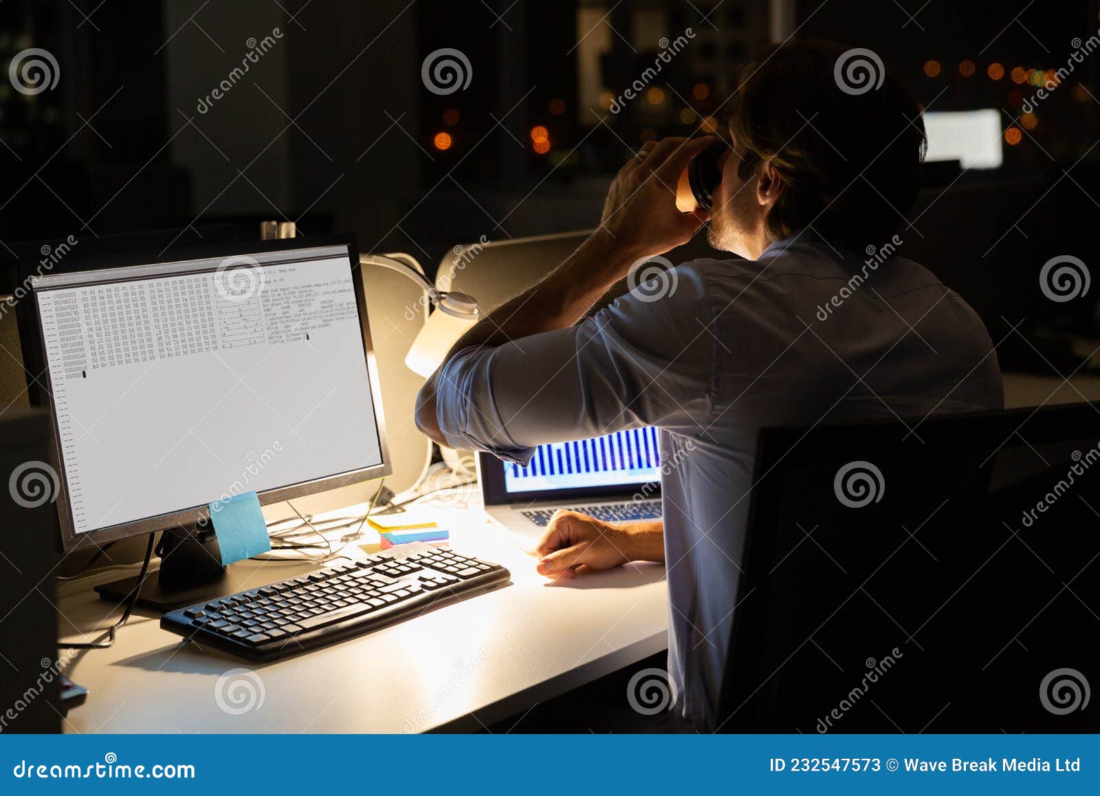 Caucasian Male Programmer Sitting at Desk, Drinking Coffee, Using Computer with Coding on Screen ...