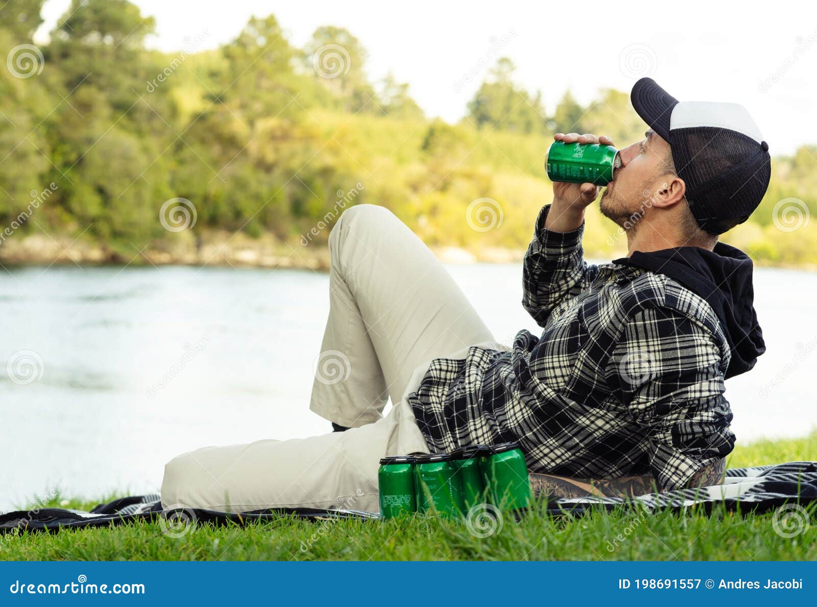 Caucasian Man Drinking Beer while Lying on the Grass by the River Stock ...