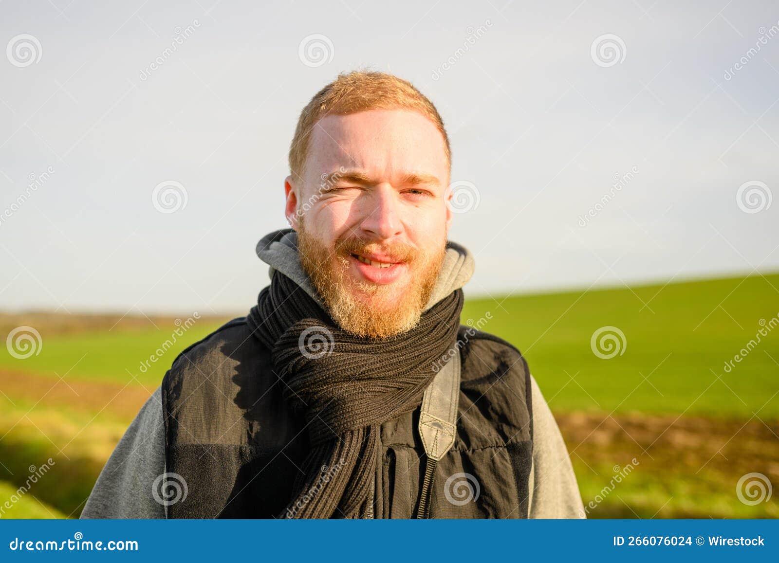 Caucasian Man Standing in a Field Staring at Camera with One Eye Closed ...