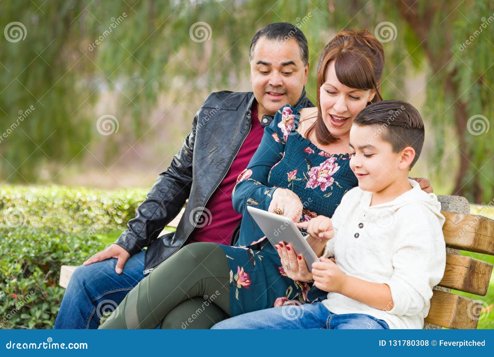Caucasian Mother and Hispanic Father Using Computer Tablet with Mixed ...
