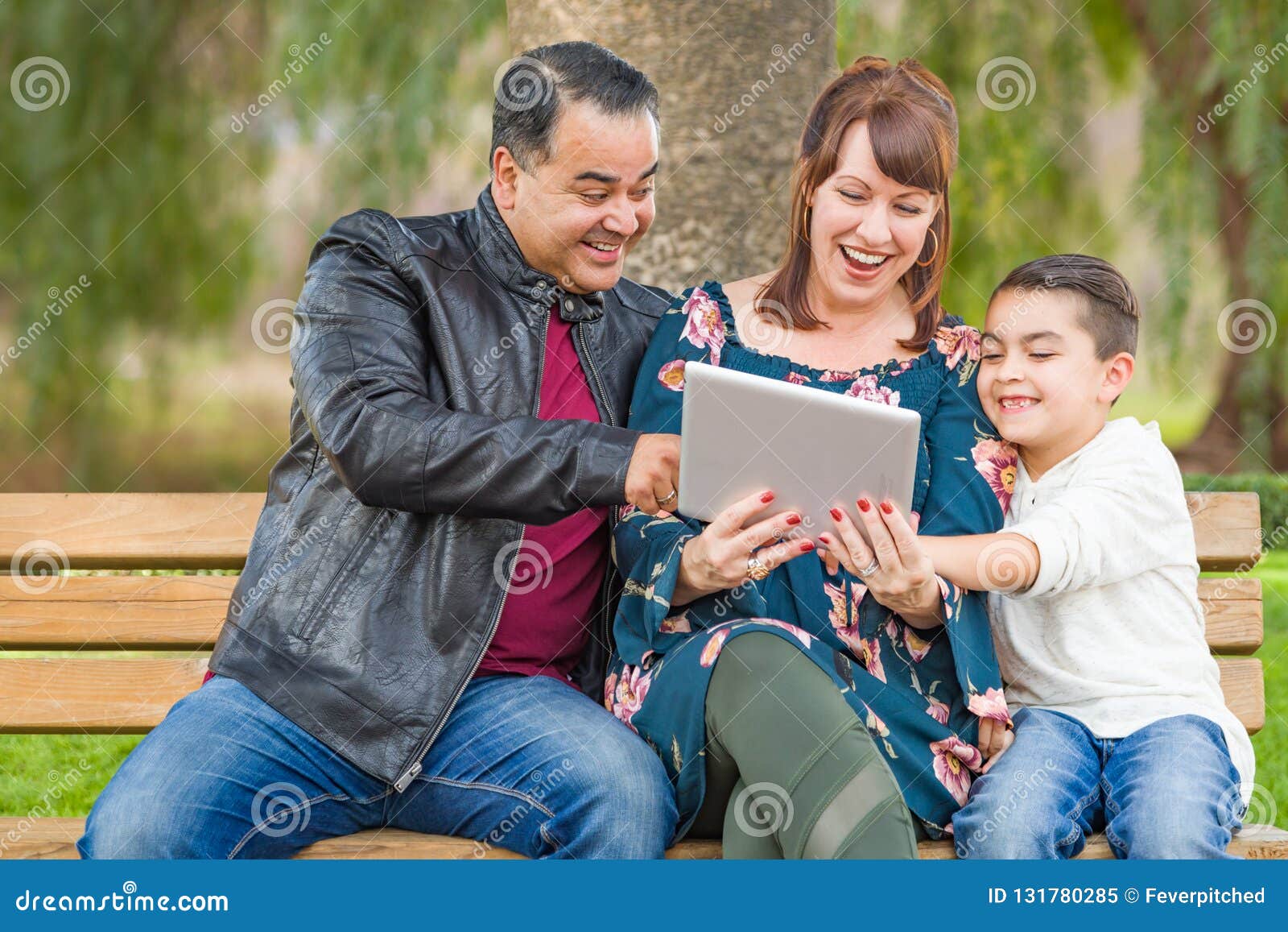 Excited Caucasian Mother and Hispanic Father Using Computer Tablet with ...