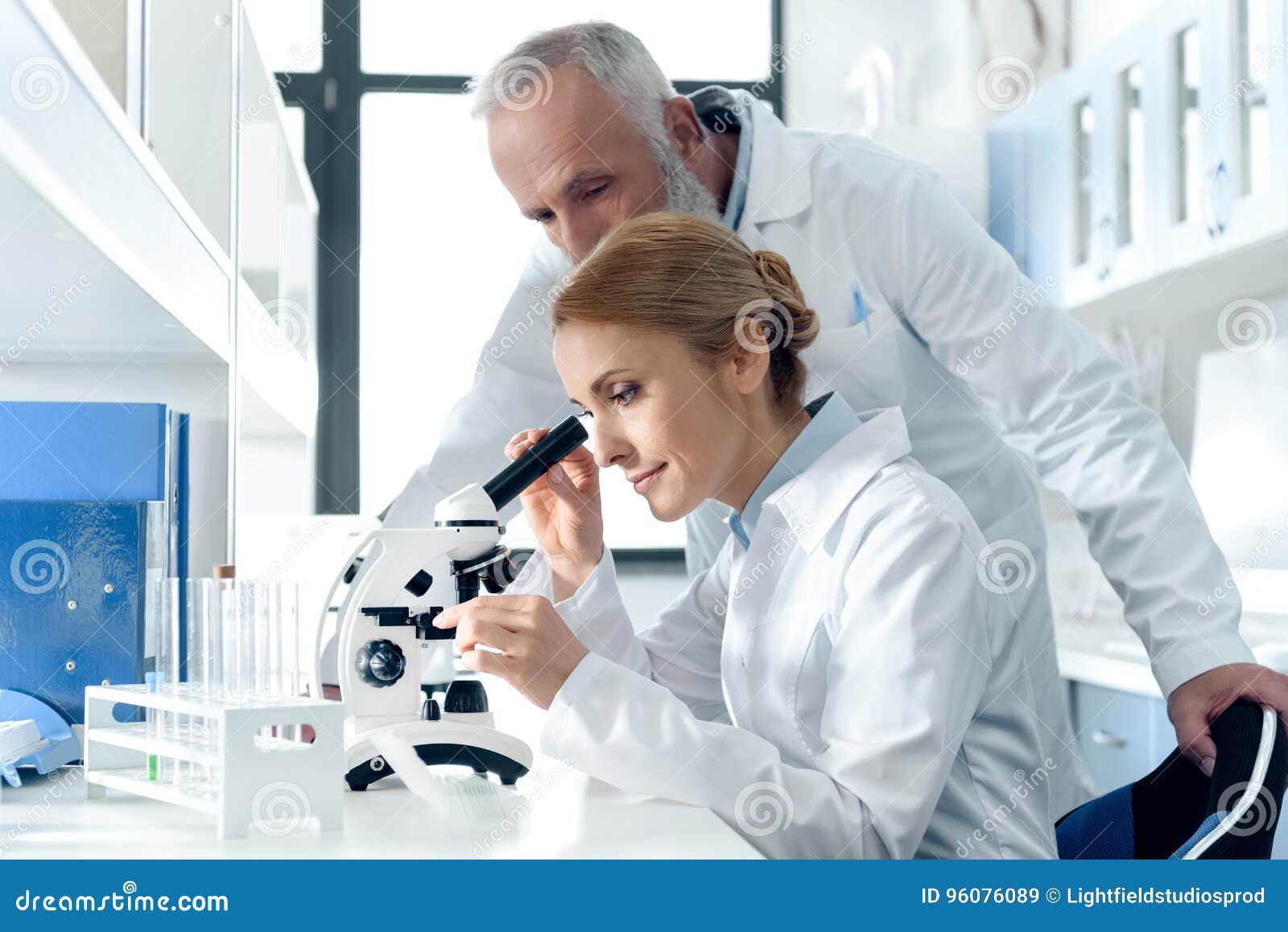 Caucasian Scientists in White Uniform Working with Microscope and ...