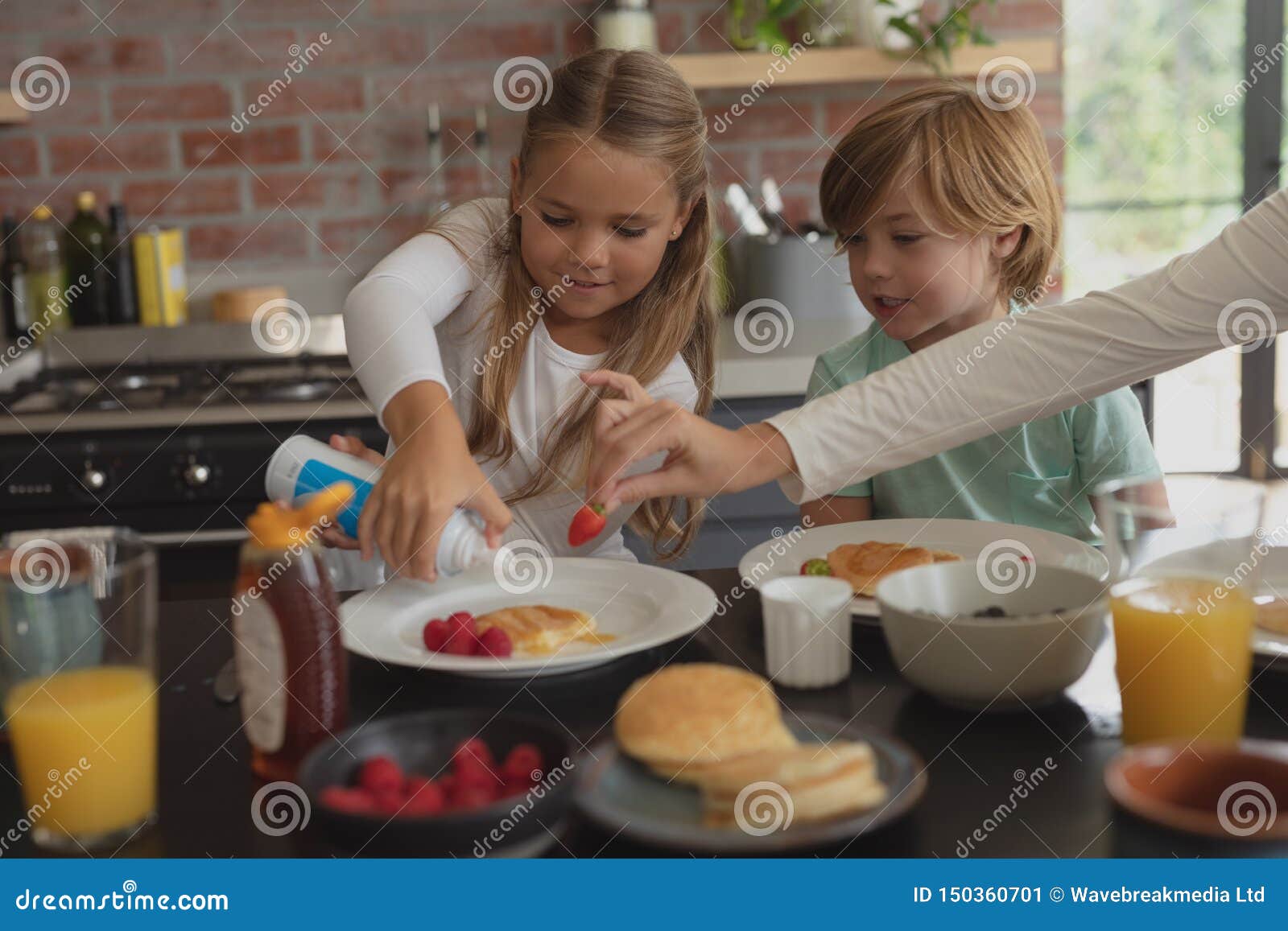 Caucasian Siblings Having Food at Dining Table Stock Image - Image of ...