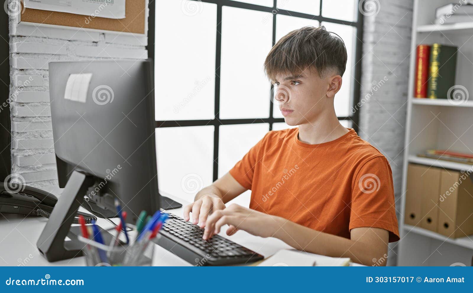 Caucasian Teen Boy Studying on Computer at Library Table, Evoking ...