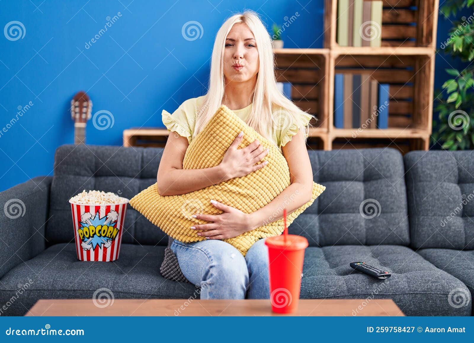 Caucasian Woman Eating Popcorn Watching A Movie At Home Puffing Cheeks