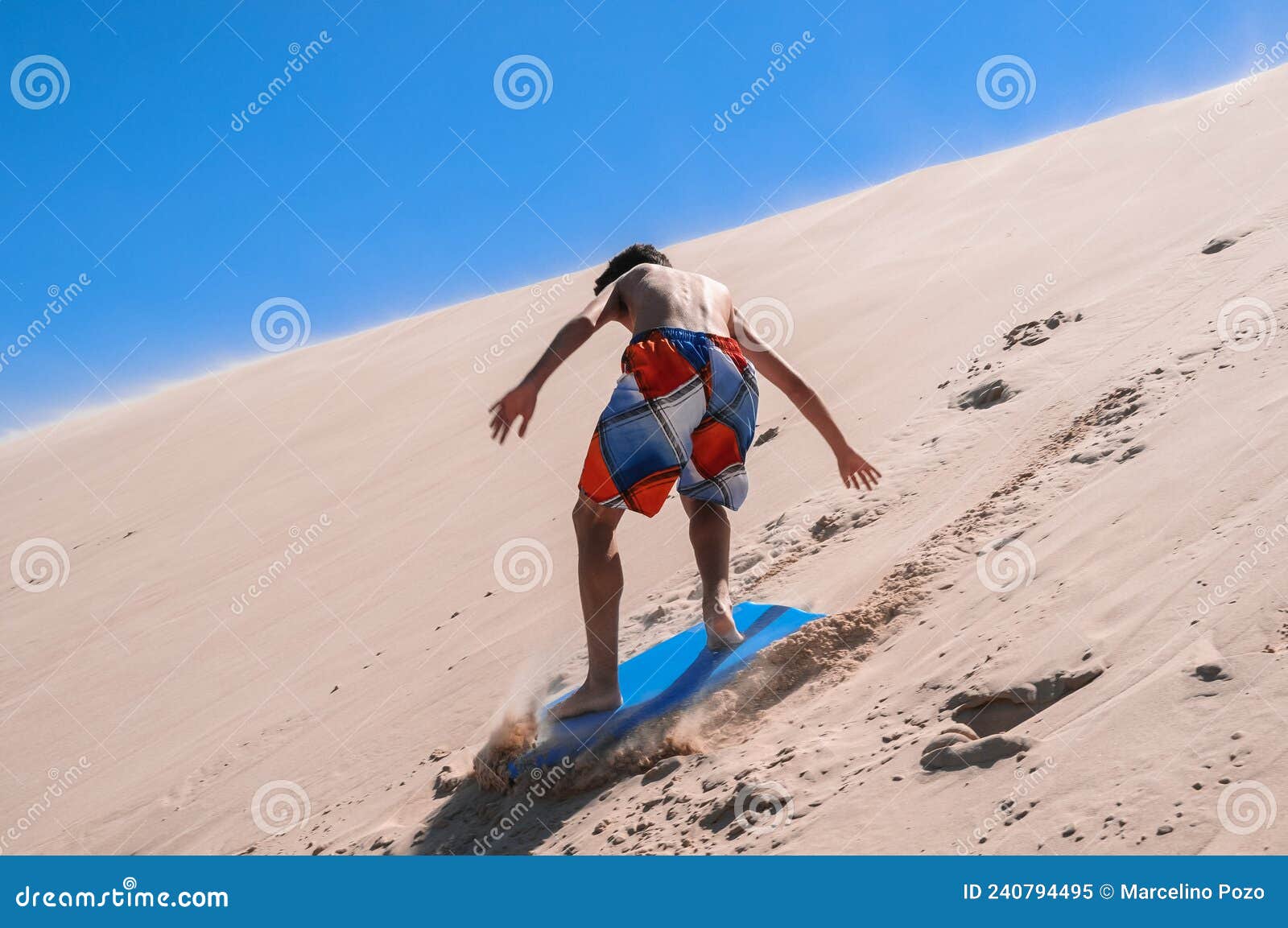 Caucasian Young Man Sliding on a Board in the Sand Stock Image - Image ...
