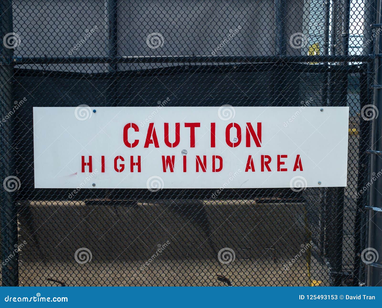 Caution High Wind Area Sign Handing on Black Fence Stock Image - Image ...