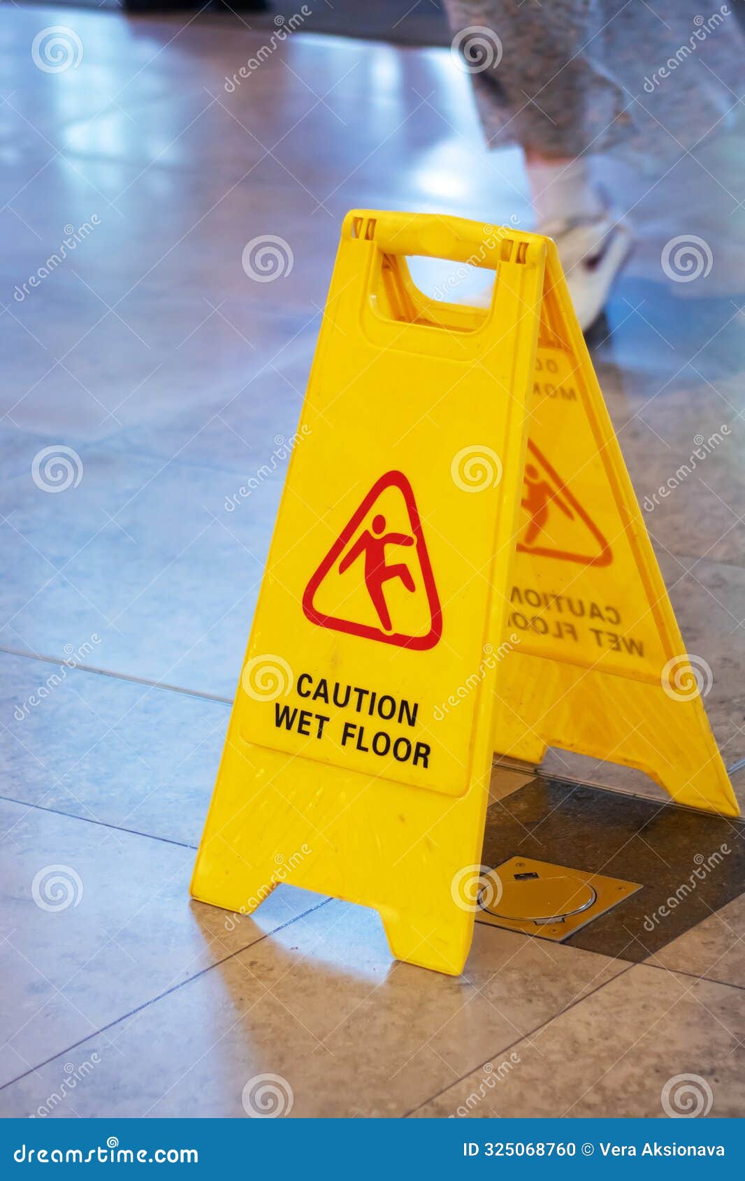 A Caution Sign Warning of Wet Floor in Yellow Displayed on Tiled ...