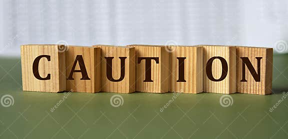 CAUTION - Word on Wooden Blocks on Light Background Stock Photo - Image ...
