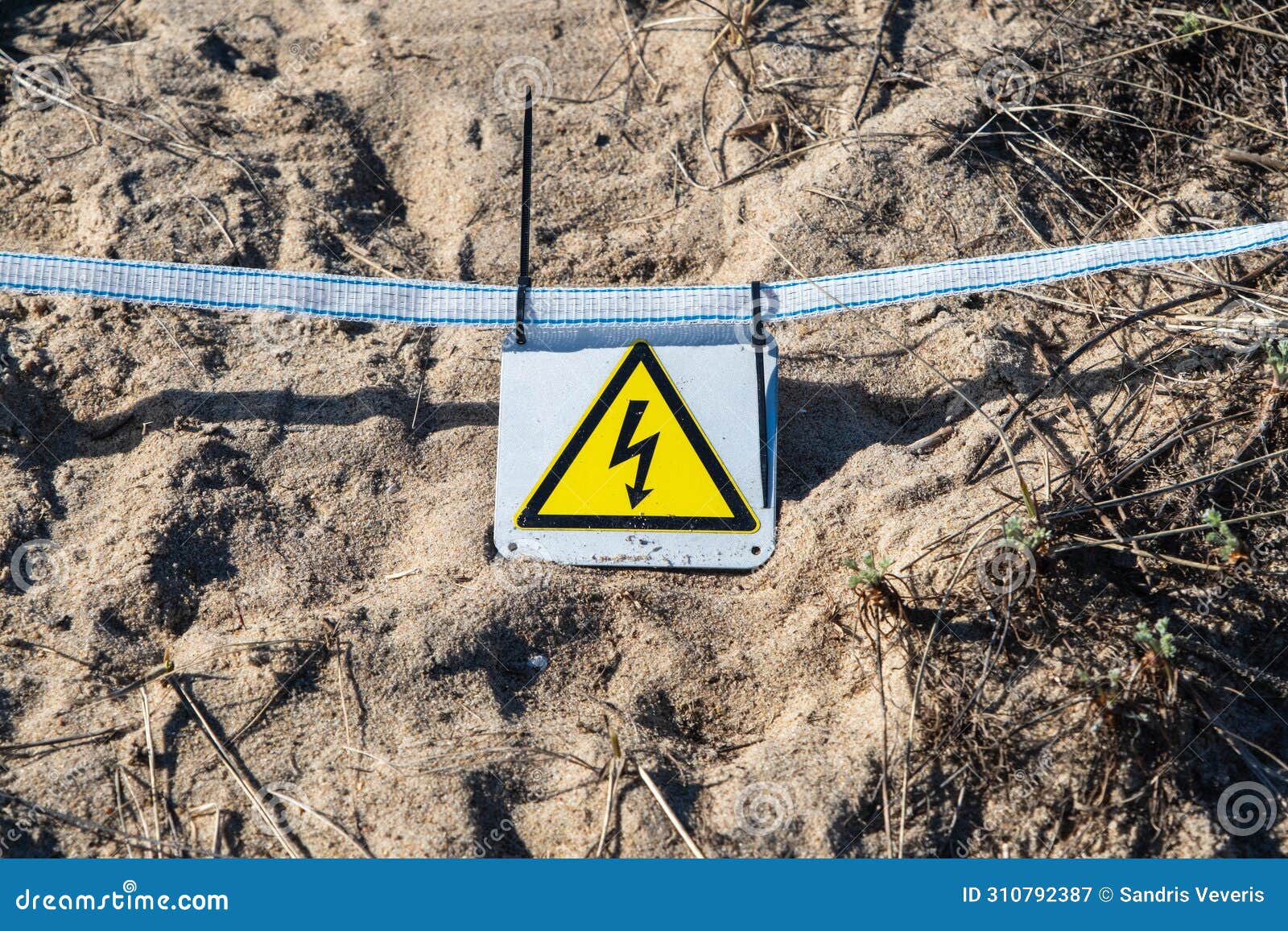 Cautionary Electrical Hazard Sign Placed on Sandy Ground. Stock Image ...