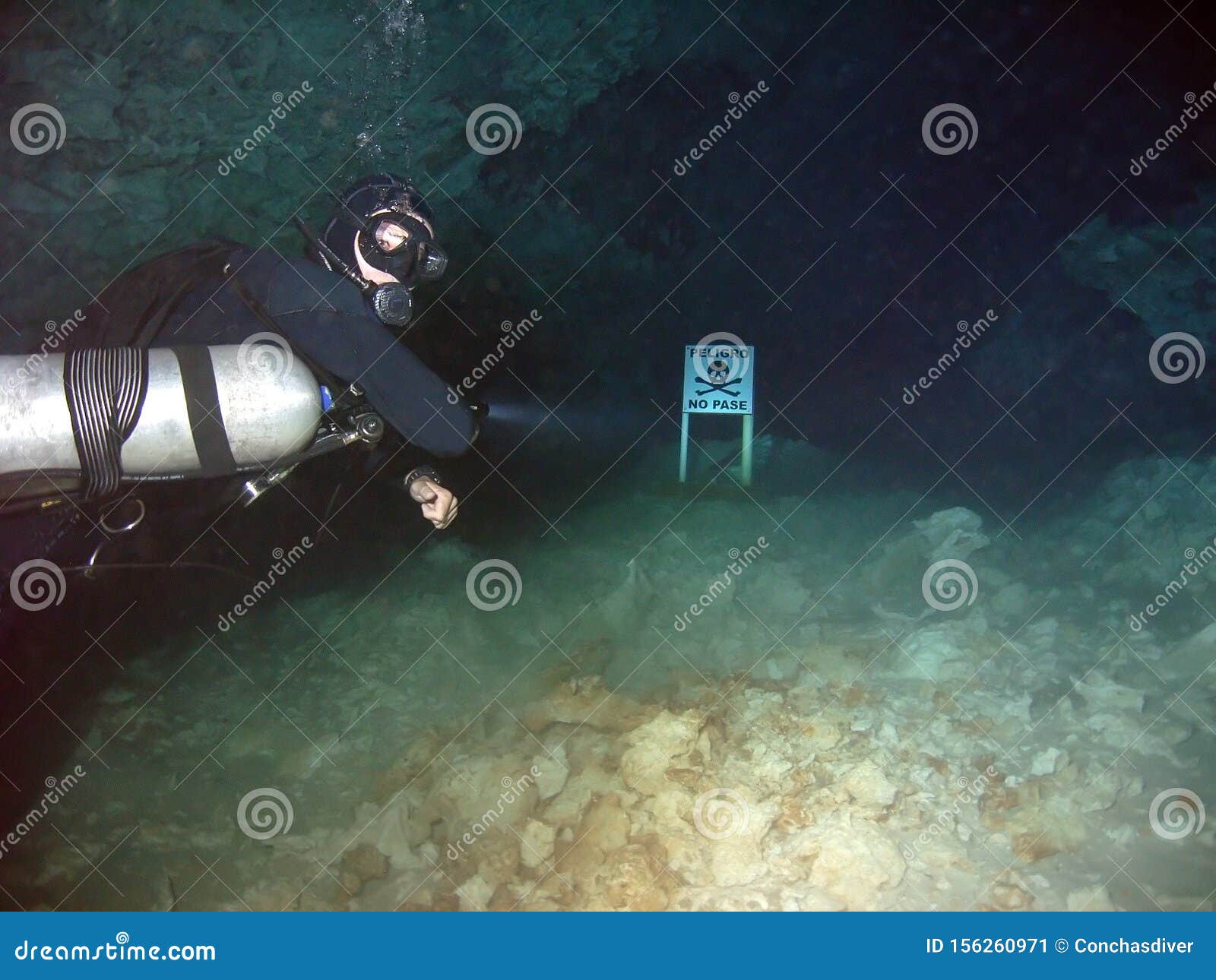A Cave Diver Points Out Danger Sign Stock Image - Image of shines, cave ...