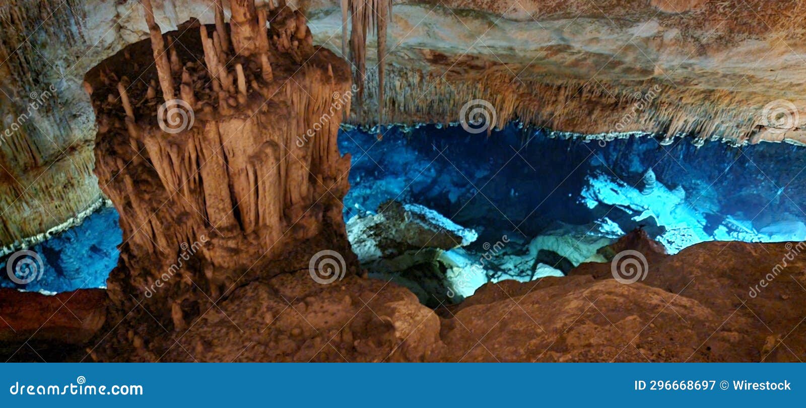 A Cave Featuring Massive Clusters of Stalactites and a Small Pool of ...