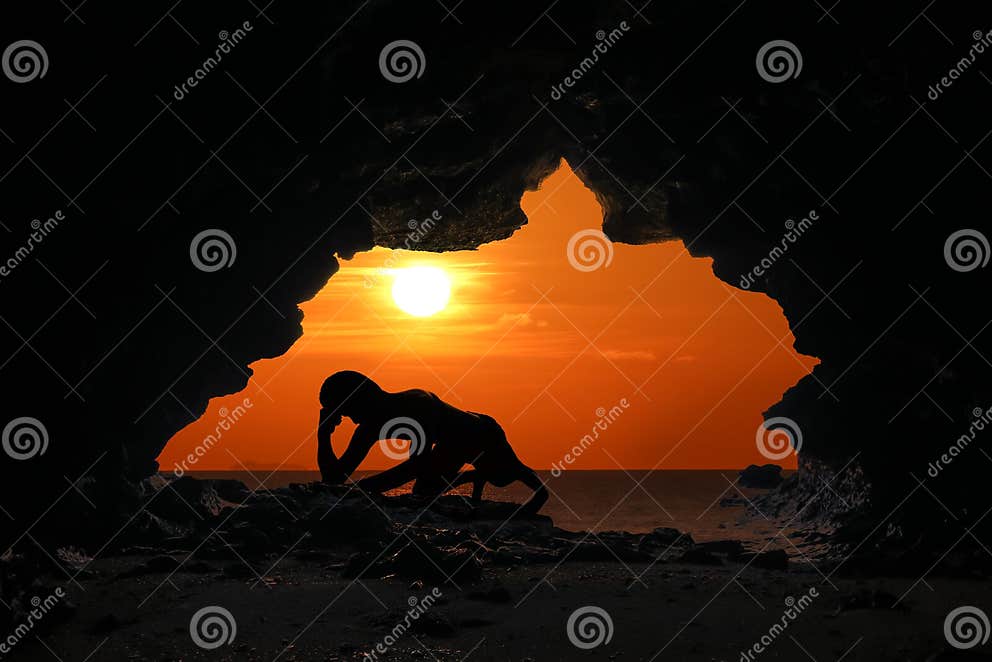 Caveman Posture or Action in the Cave at Red Sky Sunset Stock Photo ...