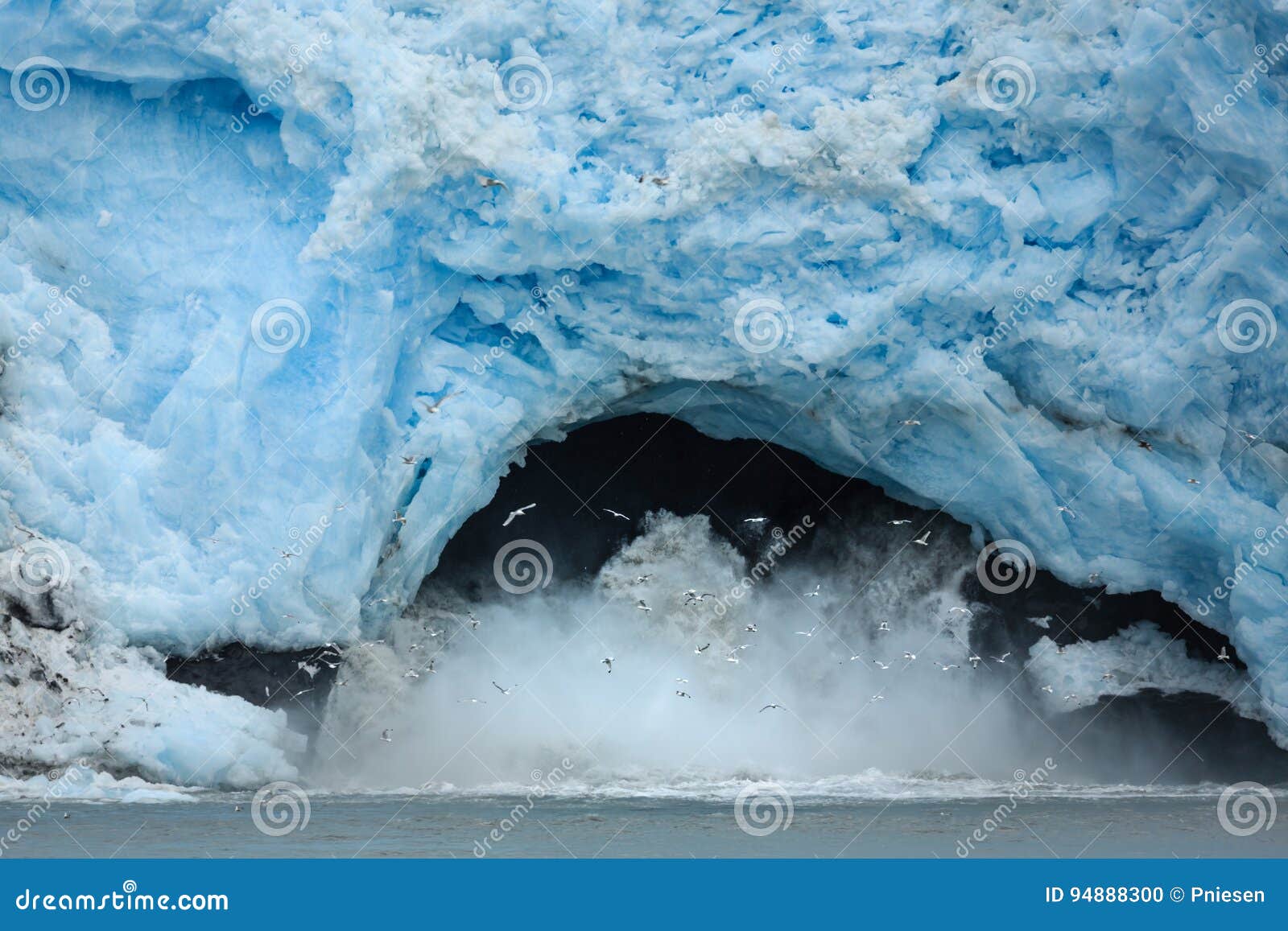 Caving Ice from Bright Blue Glacier Splashes in Water when it Falls ...