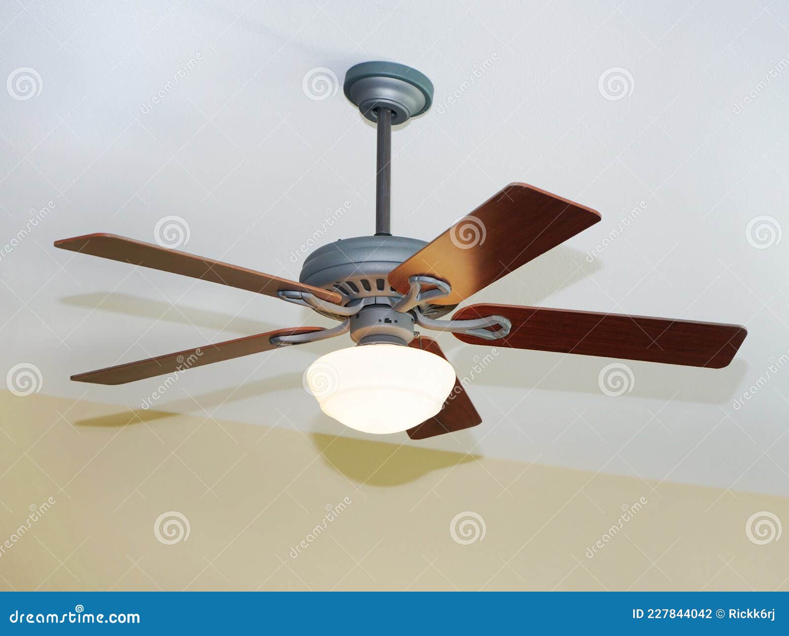 A Ceiling Fan with Light Mounted on Angled Ceiling Stock Photo - Image ...