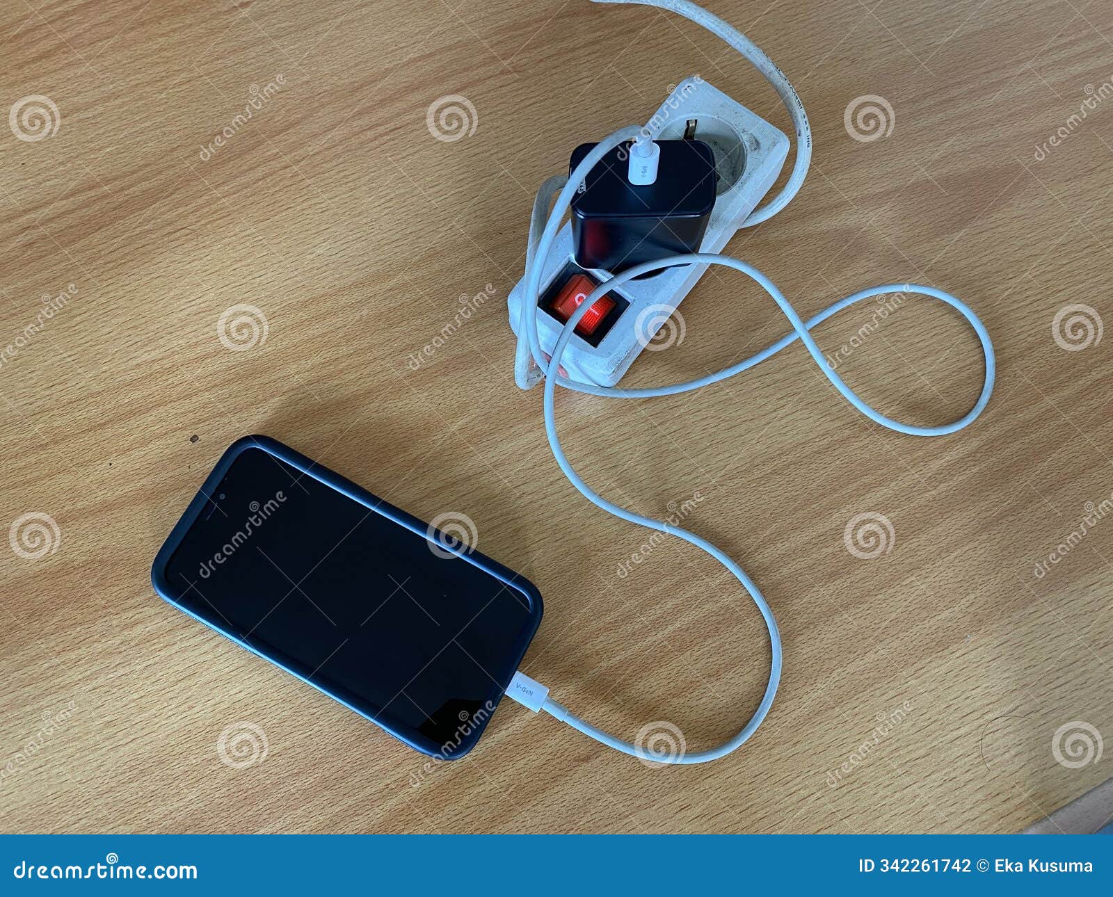 Cell Phone Being Charged on a Brown Table Stock Photo - Image of ...