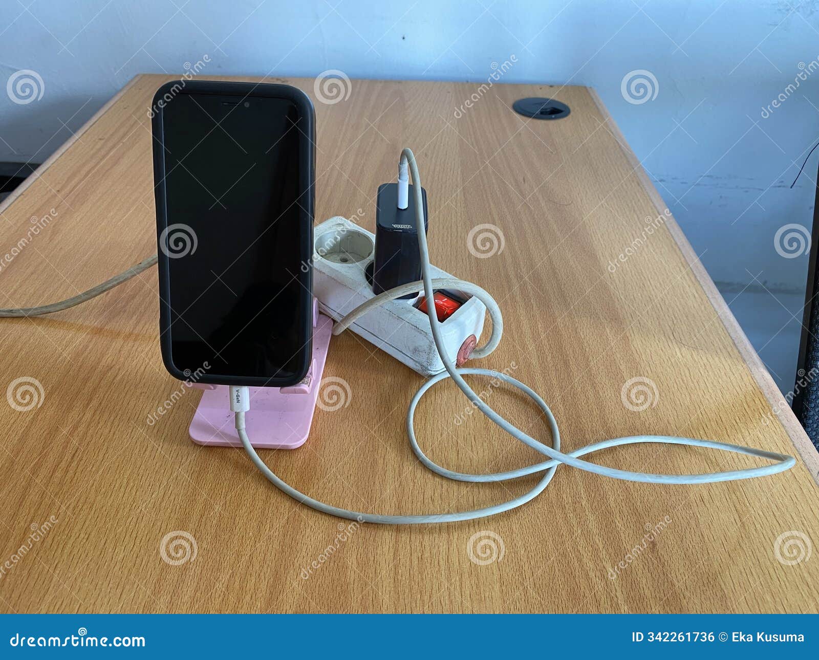 Cell Phone Being Charged on a Brown Table Stock Photo - Image of phone ...