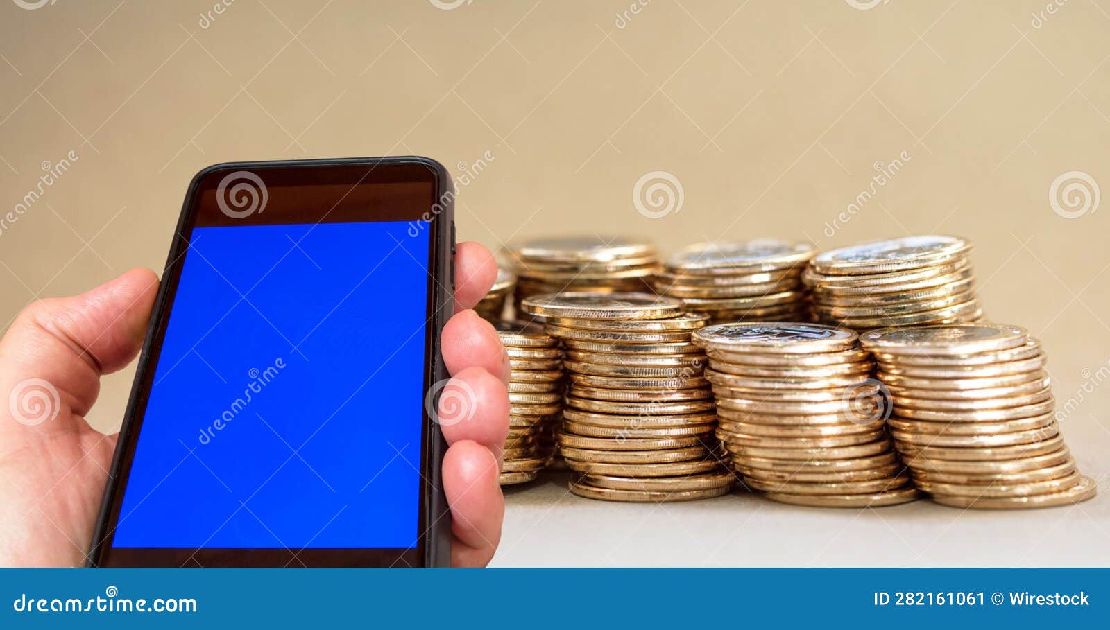 Cell Phone with a Blue Screen in Hand and a Background with Stacks of ...