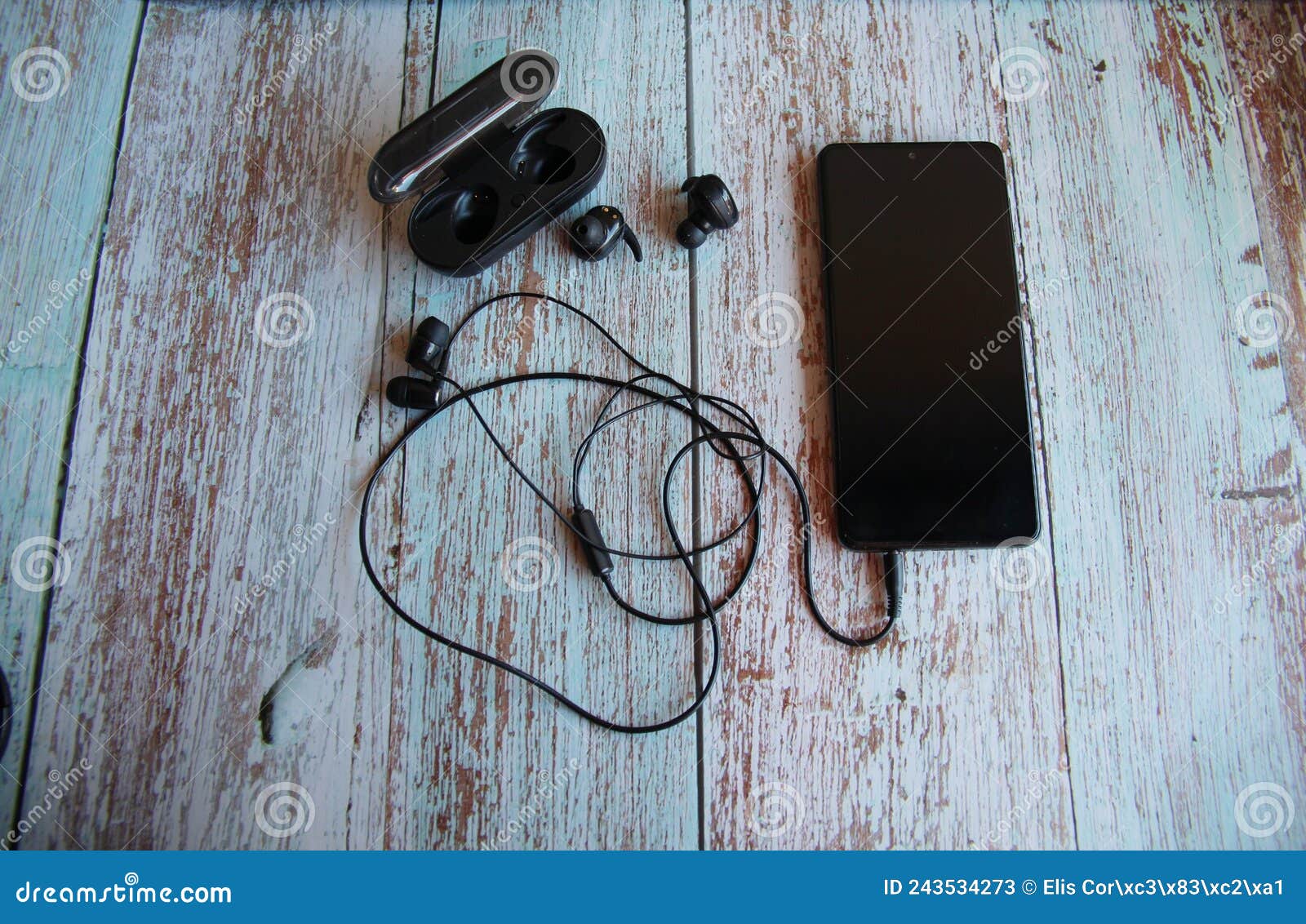 Cell Phone with Wired Headset and Bluetooth Headset, on Top of a Wooden ...
