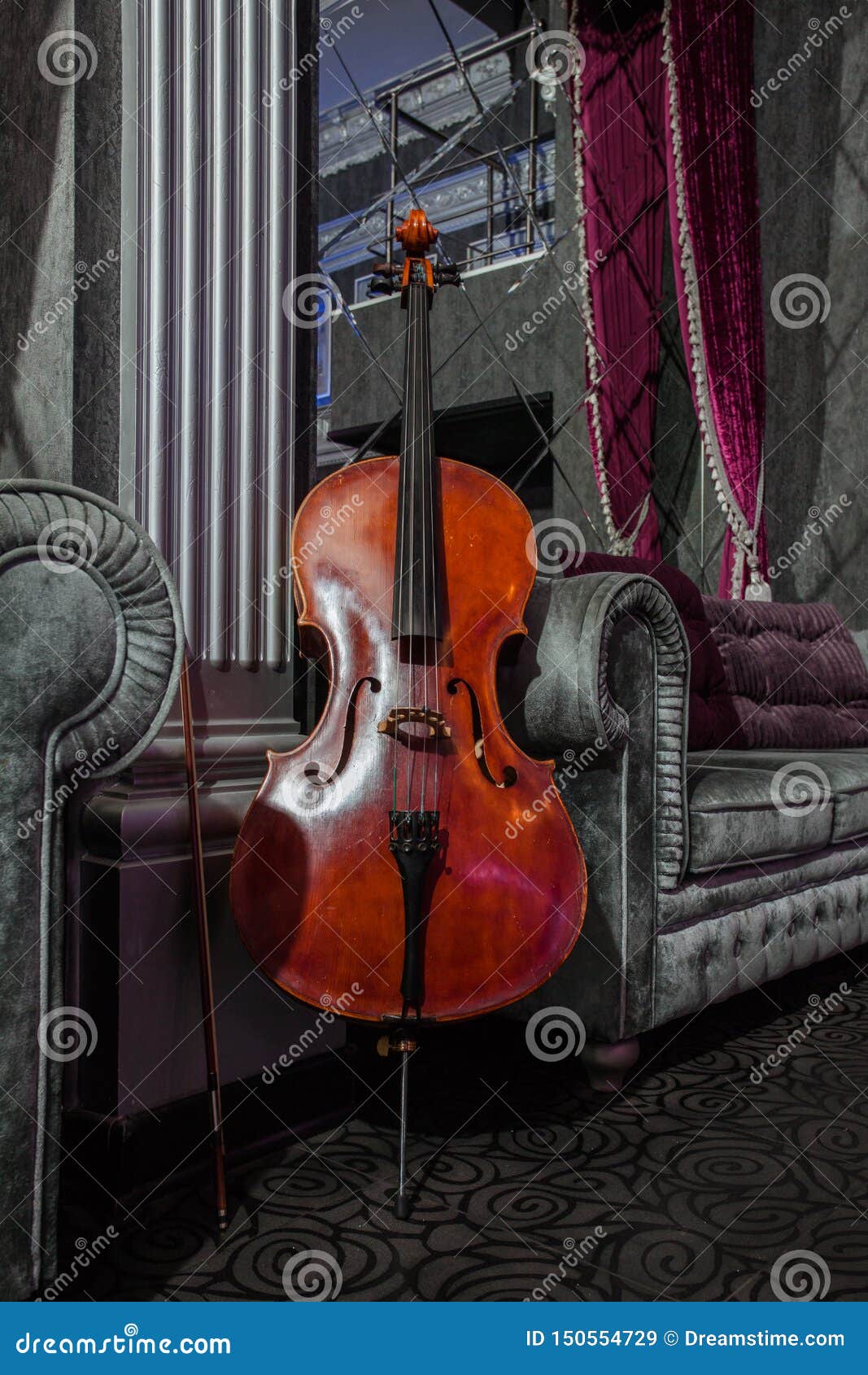 Cello on grey couch stock image. Image of grey, life - 150554729