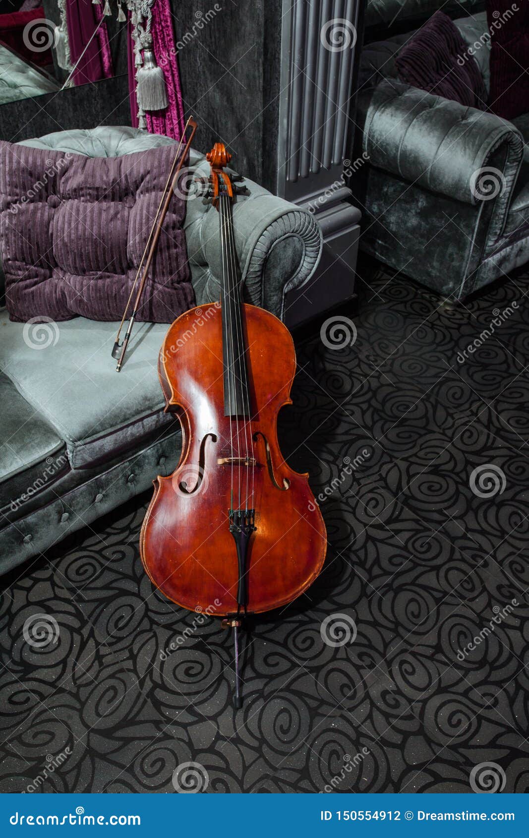 Cello on grey couch stock photo. Image of calm, grey - 150554912