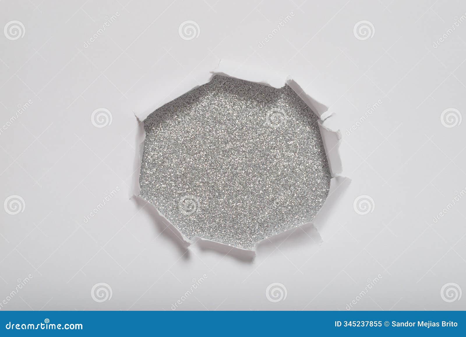 Center Torn Hole in White Paper Revealing a Silver Glitter Texture ...