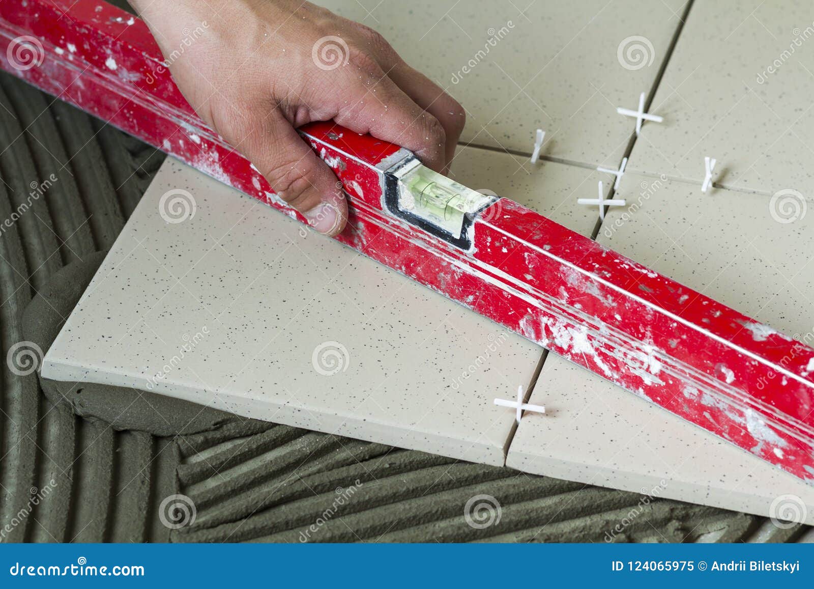 Ceramic Tiles and Tools for Tiler. Worker Hand Installing Floor Tiles ...