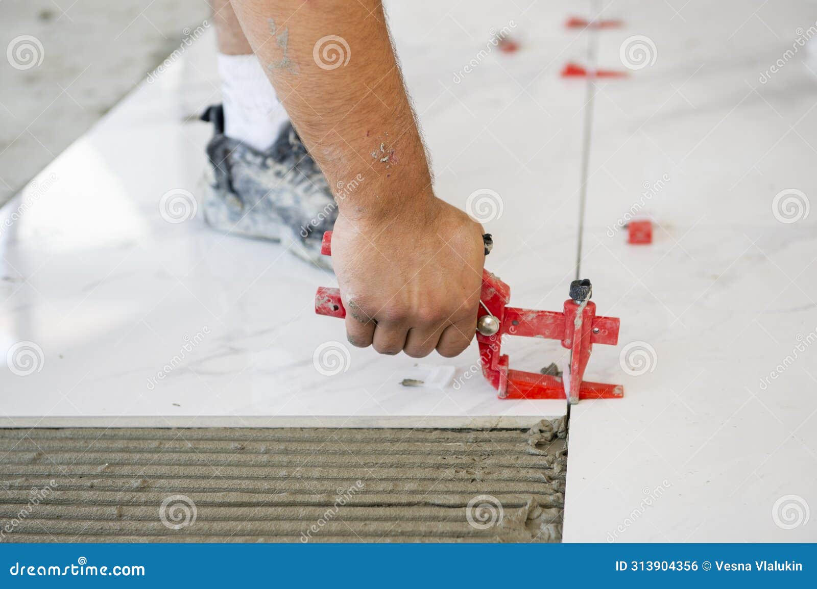 Ceramic White Floor Tiles Laid Over Adhesive with a Tile Leveling ...