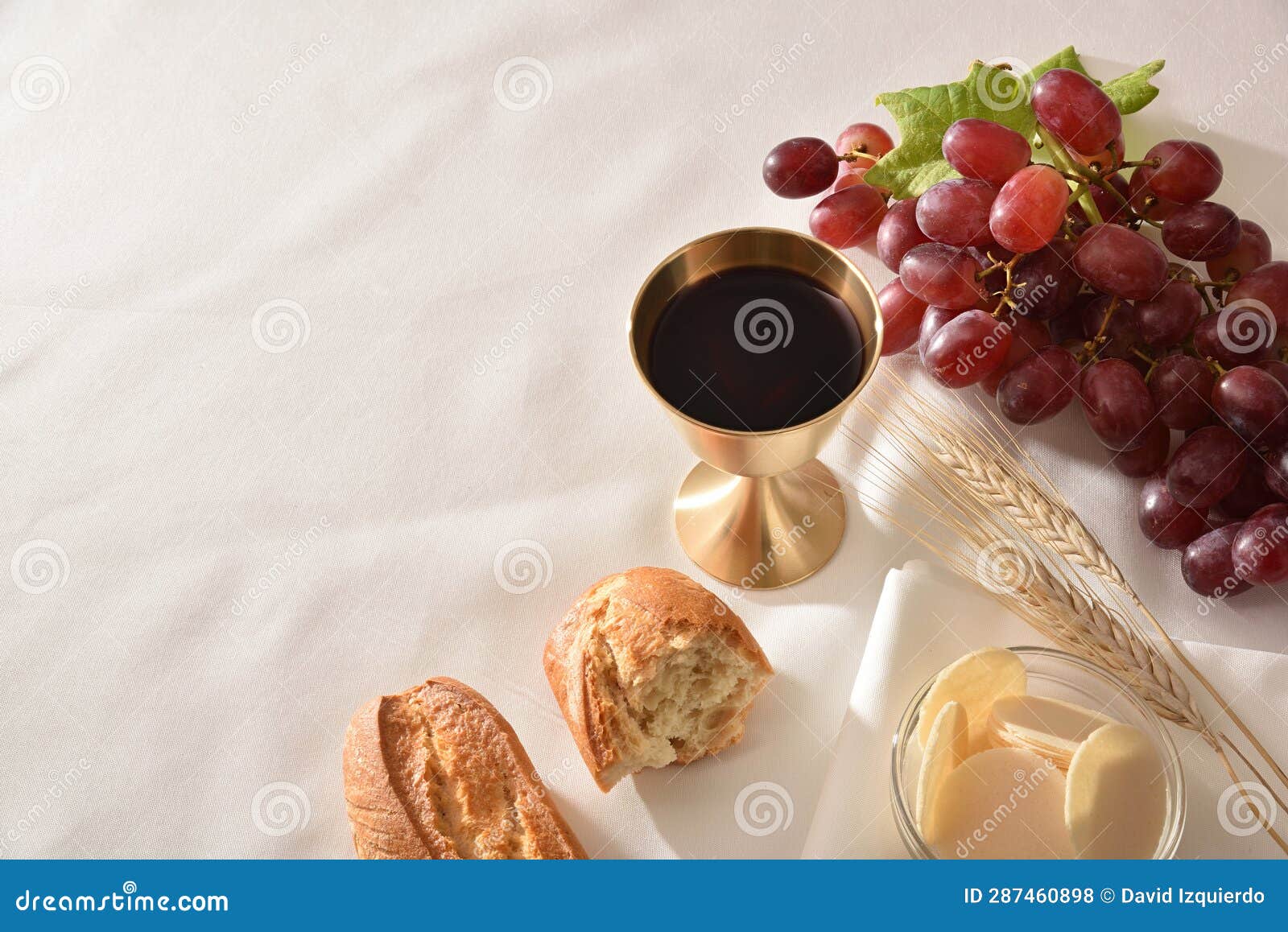 Chalice on Table with Bread and Grapes in the Background Stock Photo ...