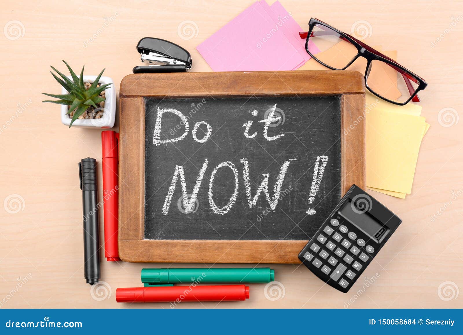 Chalkboard with Phrase "Do it Now " and Stationery on Table. Time ...