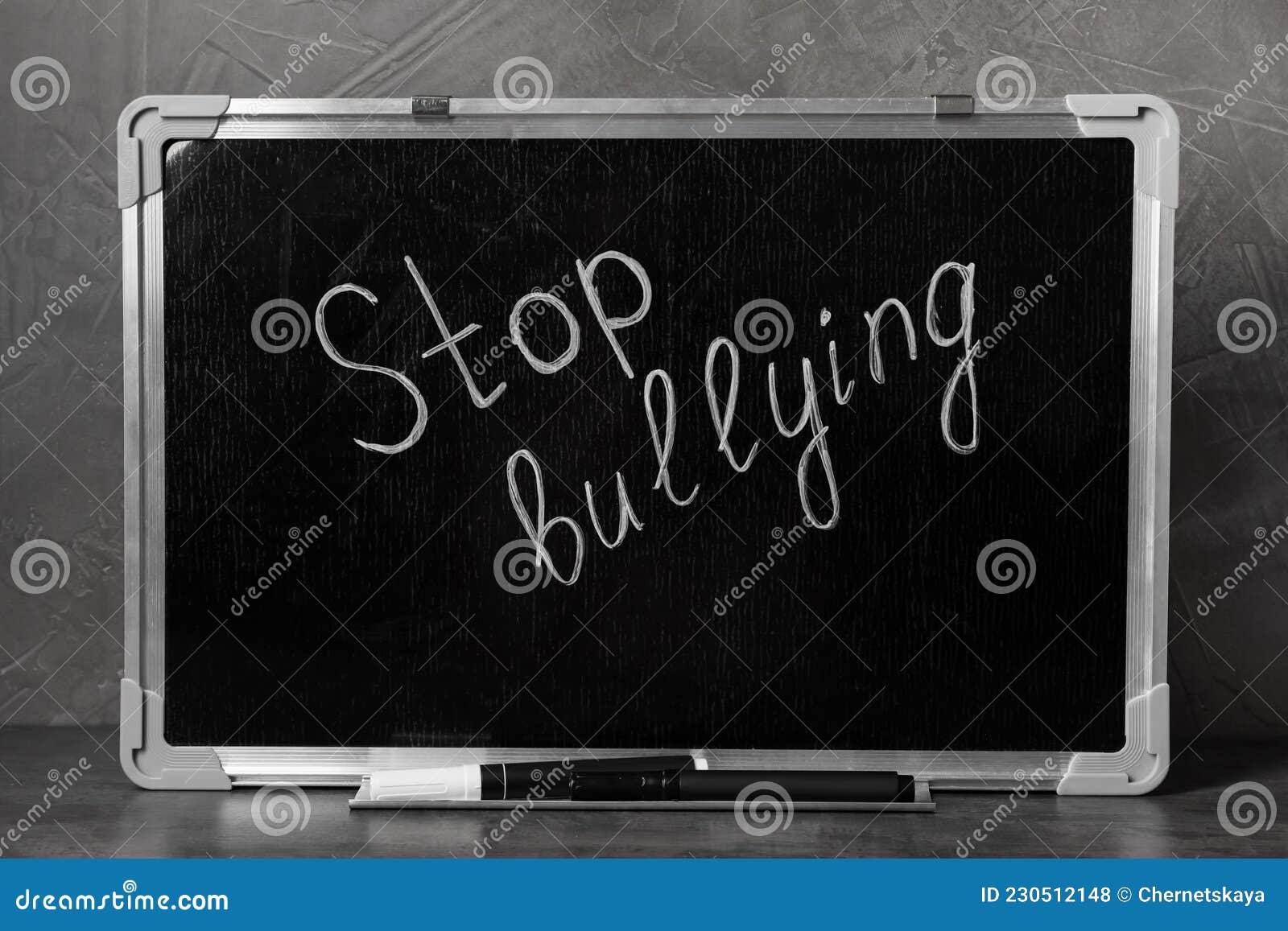 Chalkboard with Phrase Stop Bullying on Table Near Grey Wall Stock ...